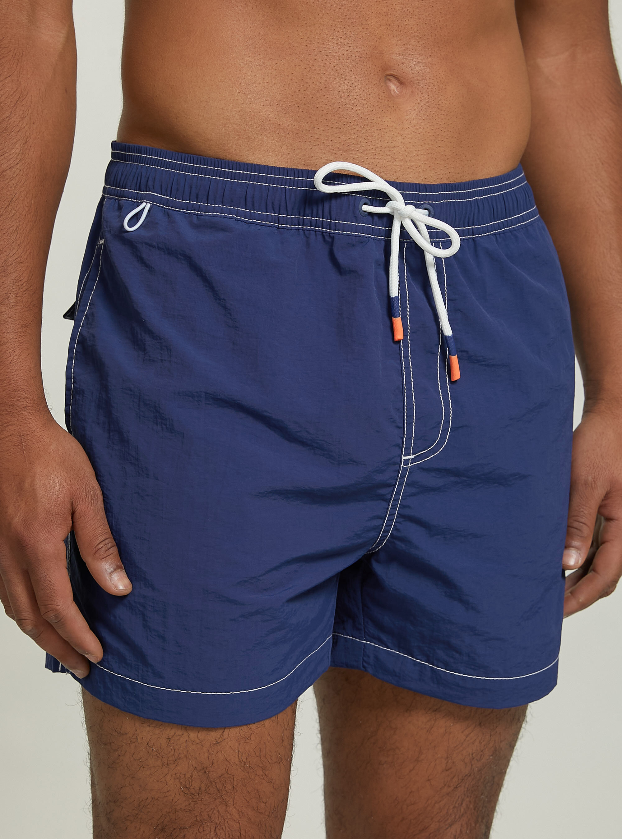 Plain-coloured swimming costume with embroidery and back pocket ...